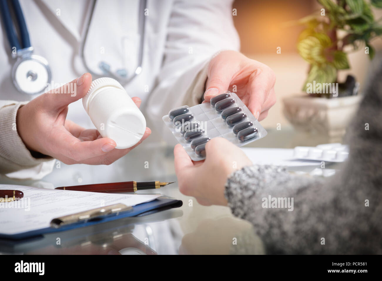 Doctor showing medicines to her patient in the doctor's office Stock ...