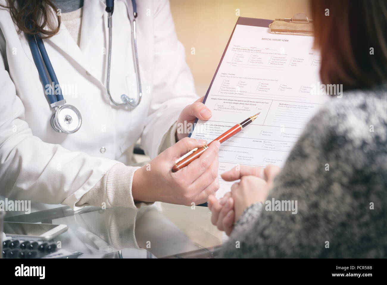 Medical doctor presenting medical history form to her patient Stock ...