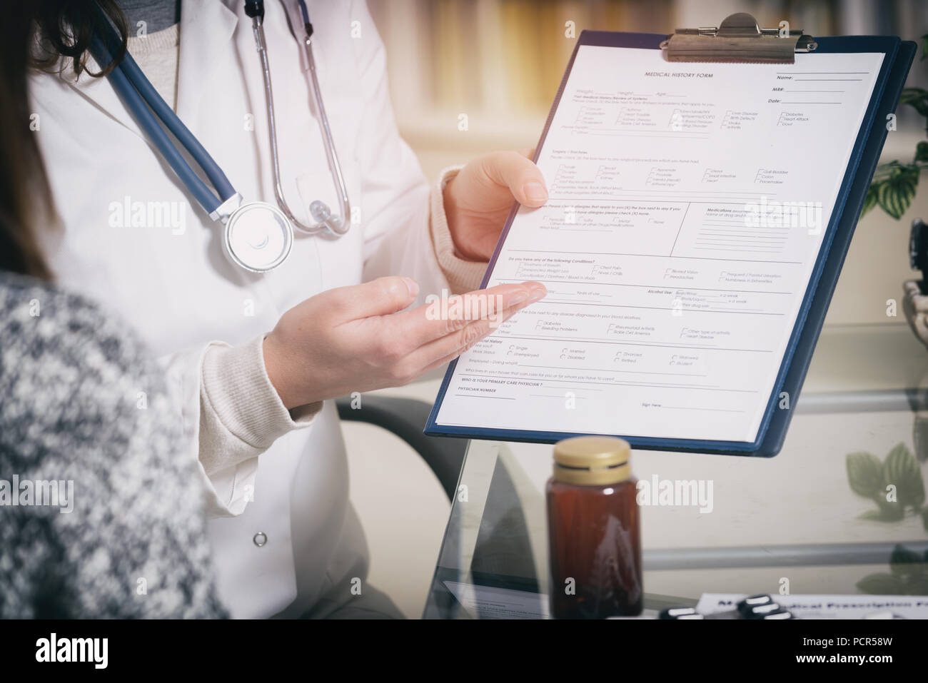 Medical doctor presenting medical history form to her patient Stock ...