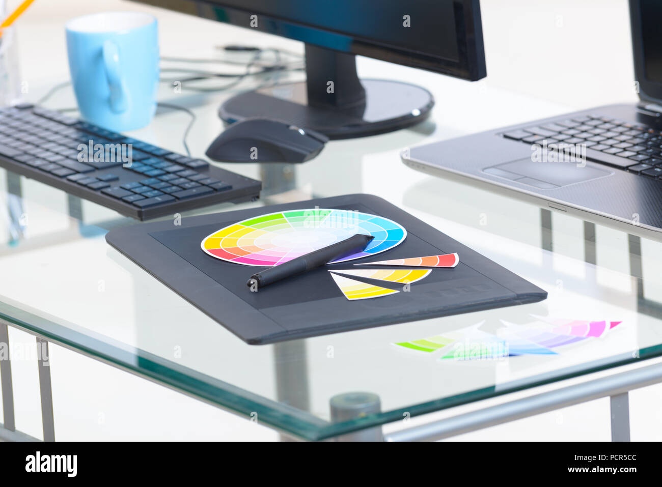 Designer workplace, computers. color wheel and swatches of colour with ...