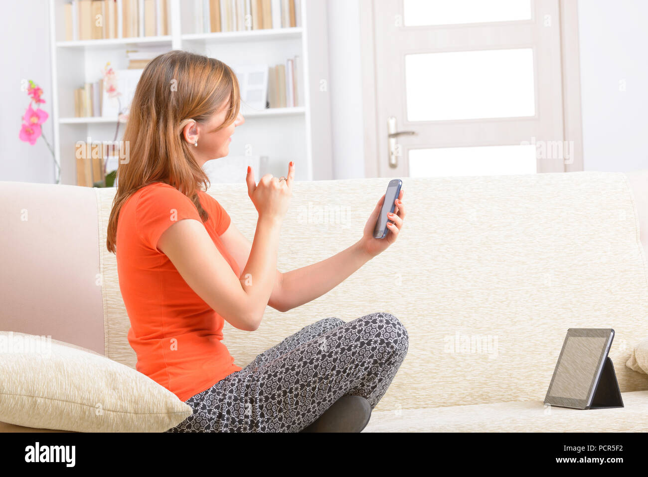 Smiling Deaf woman talking using sign language on the smartphone's cam ...
