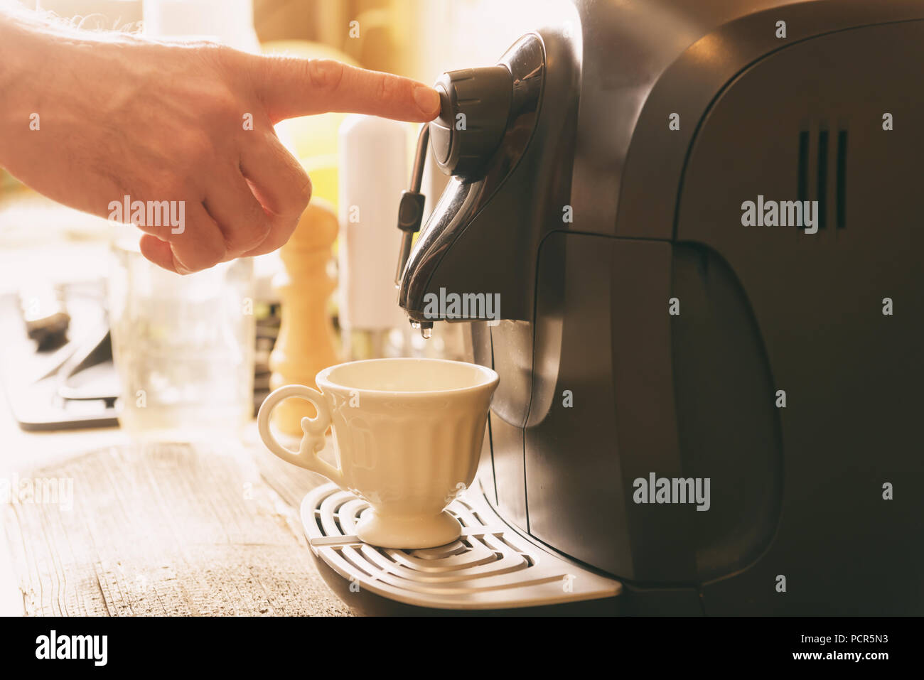 Hand on a coffee machine pressing a button to make a fresh coffee Stock ...