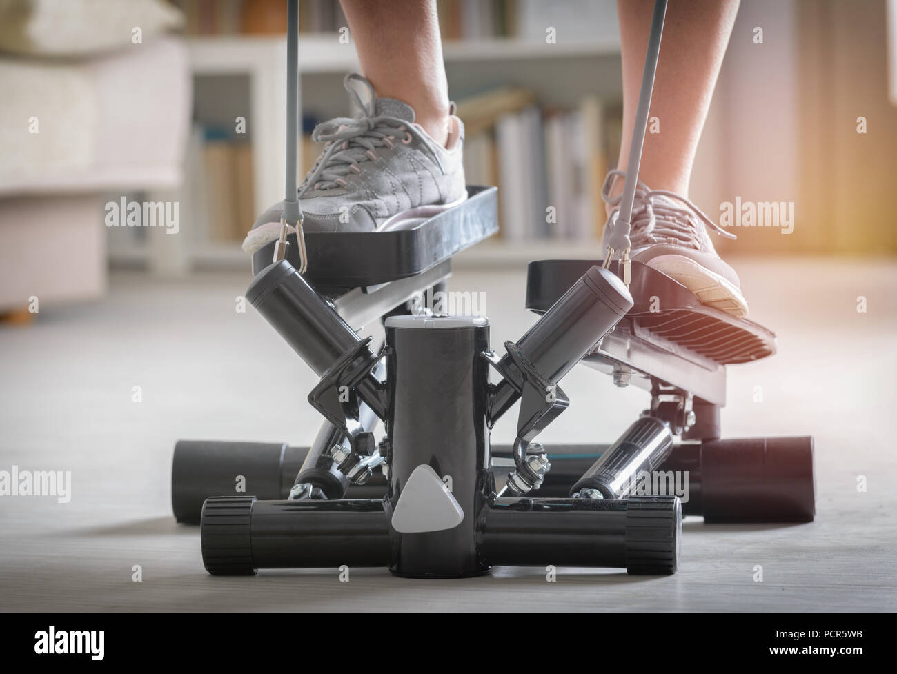 Woman doing exercises on stepper at home Stock Photo - Alamy