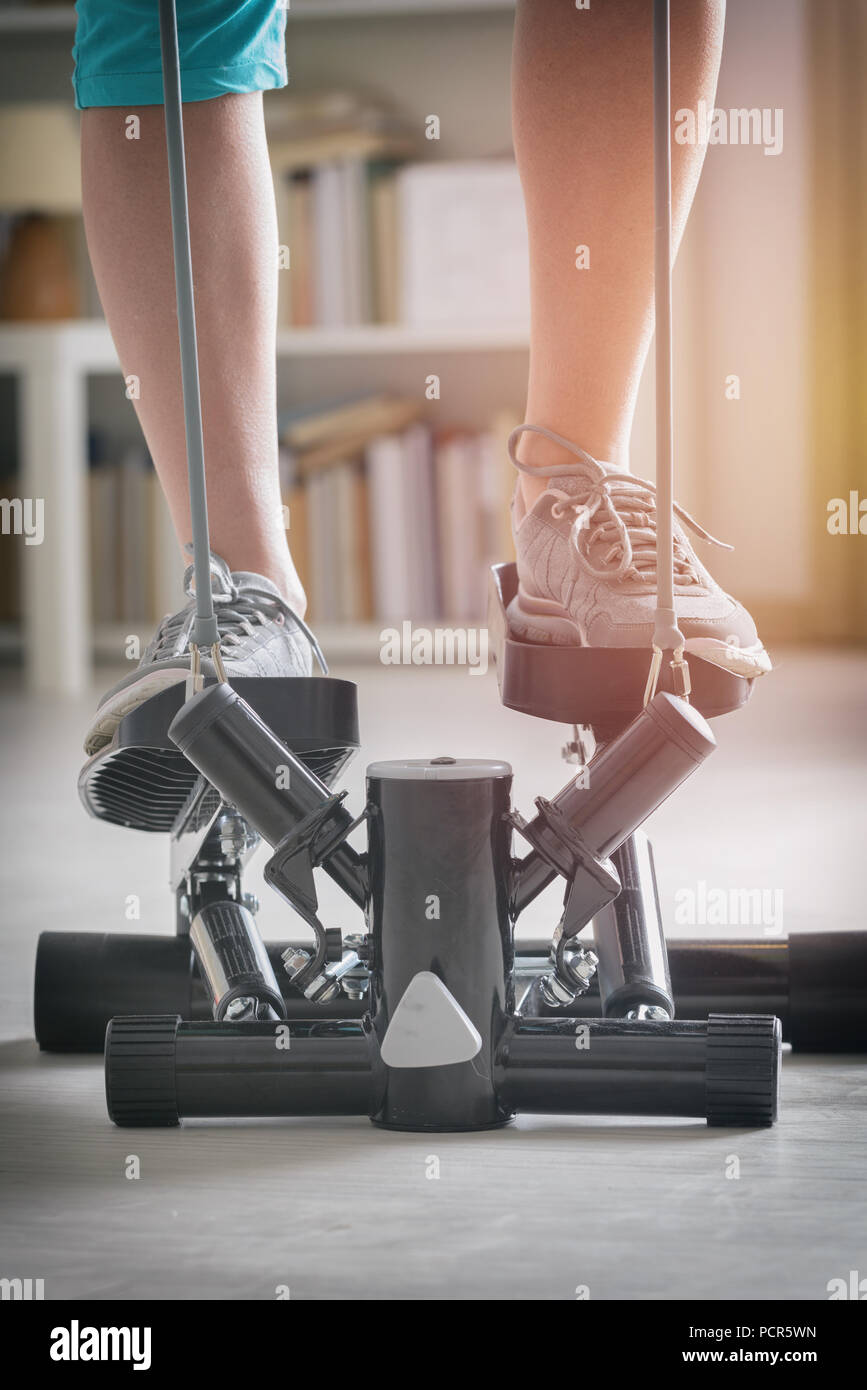 Woman doing exercises on stepper at home Stock Photo - Alamy