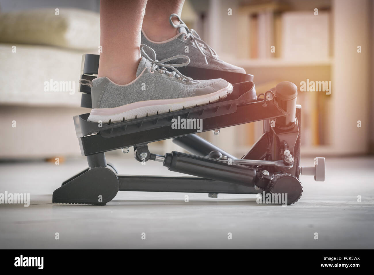 Woman doing exercises on stepper at home Stock Photo - Alamy