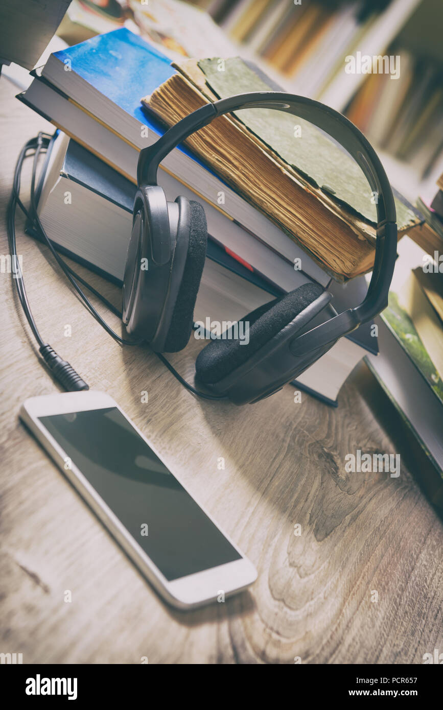 Smart phone with headphones and the paper books. Concept of listening ...