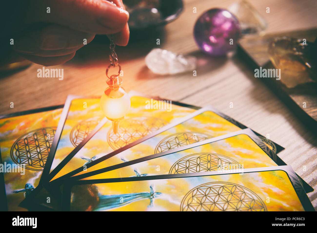 Tarot cards dowsing tool in hand and crystals as a concept of psychic ...