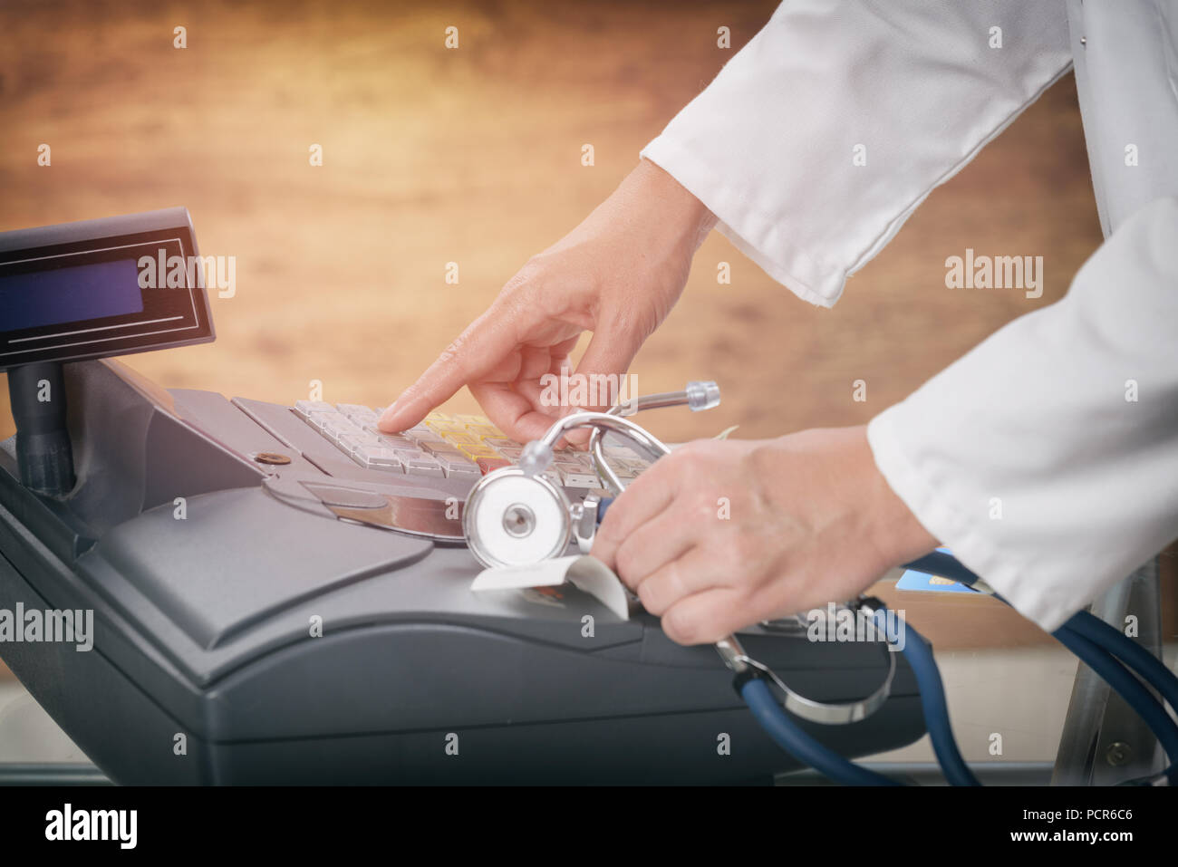 pharmacist or medical doctor holdnig stethoscope and using cash ...