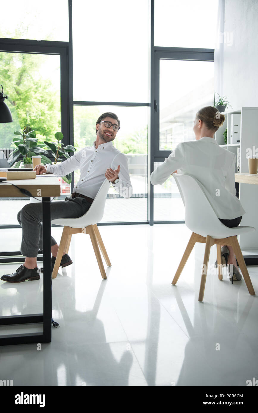 happy young managers talking at workplace in modern office Stock Photo ...