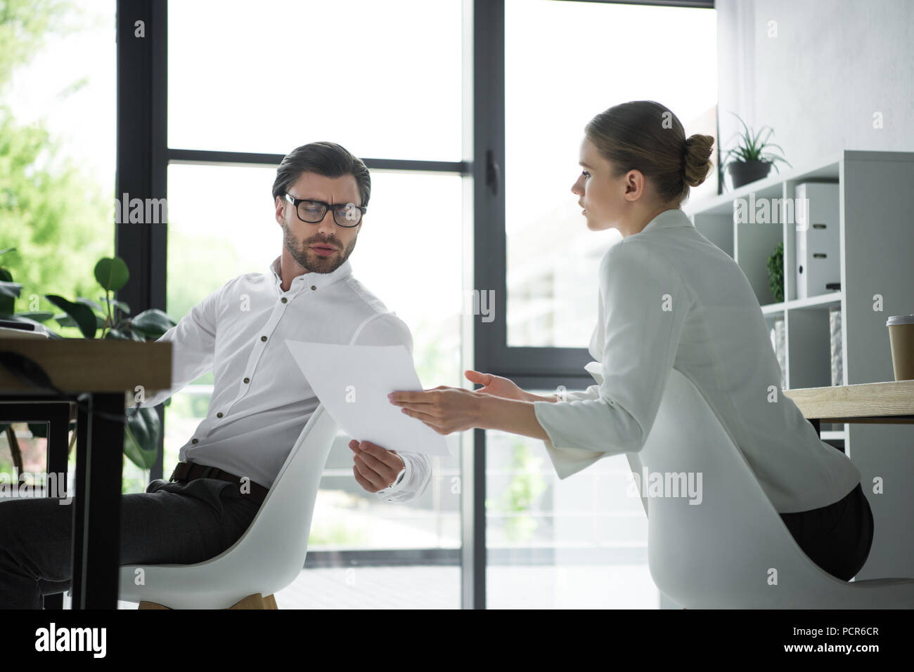 Confident businesspeople passing documents hi-res stock photography and ...