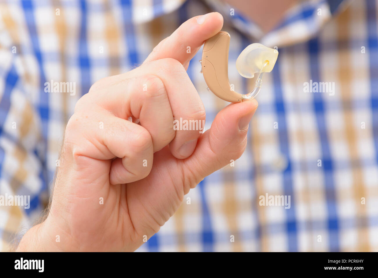 Man showing deaf aid in hand Stock Photo - Alamy