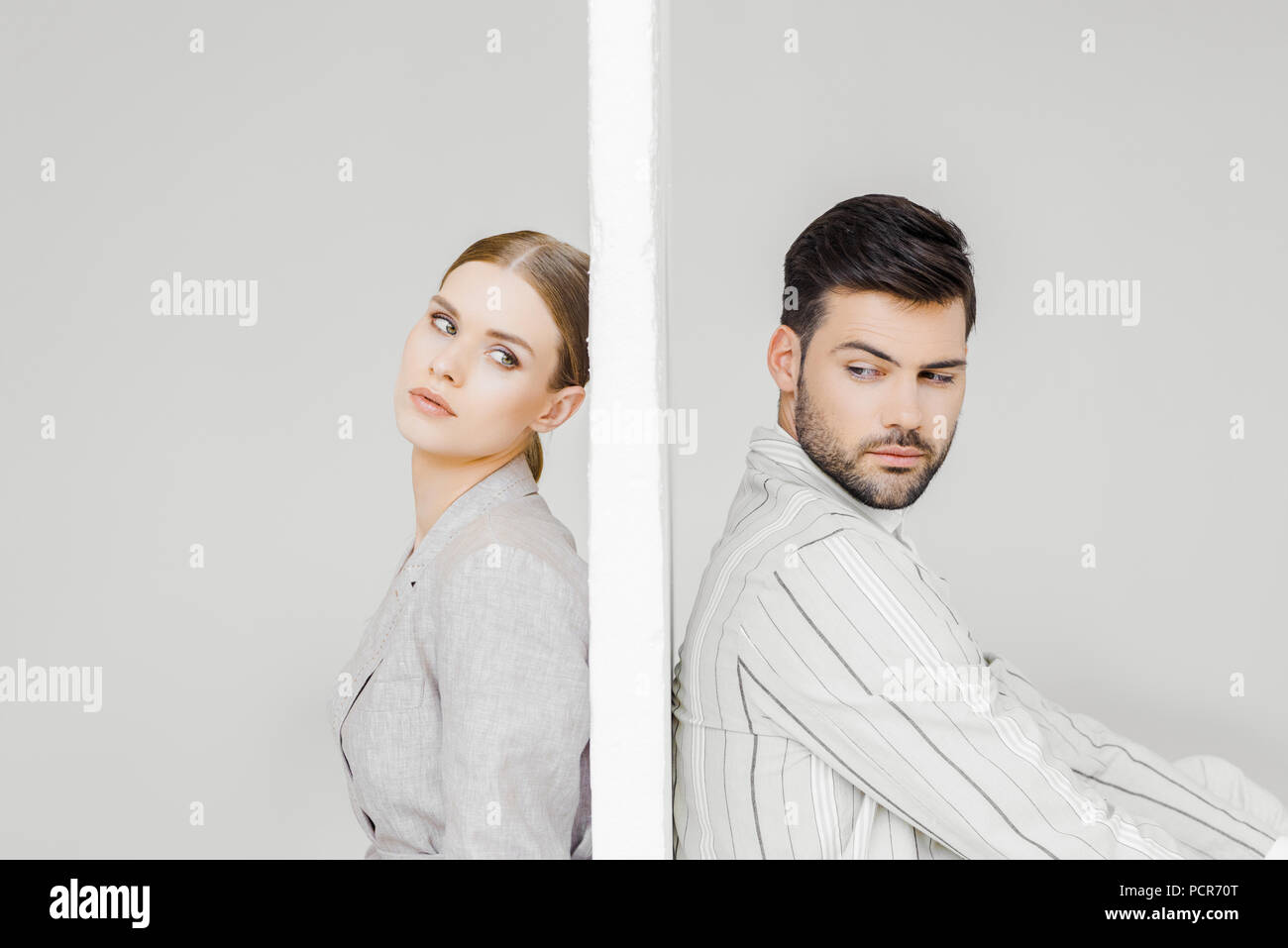 side view of attractive couple of models in stylish jackets leaning ...