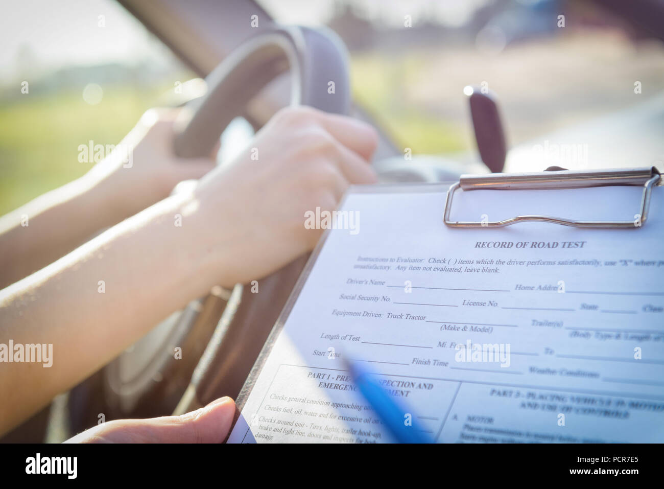 Examiner filling in driver's license road test form sitting with her ...