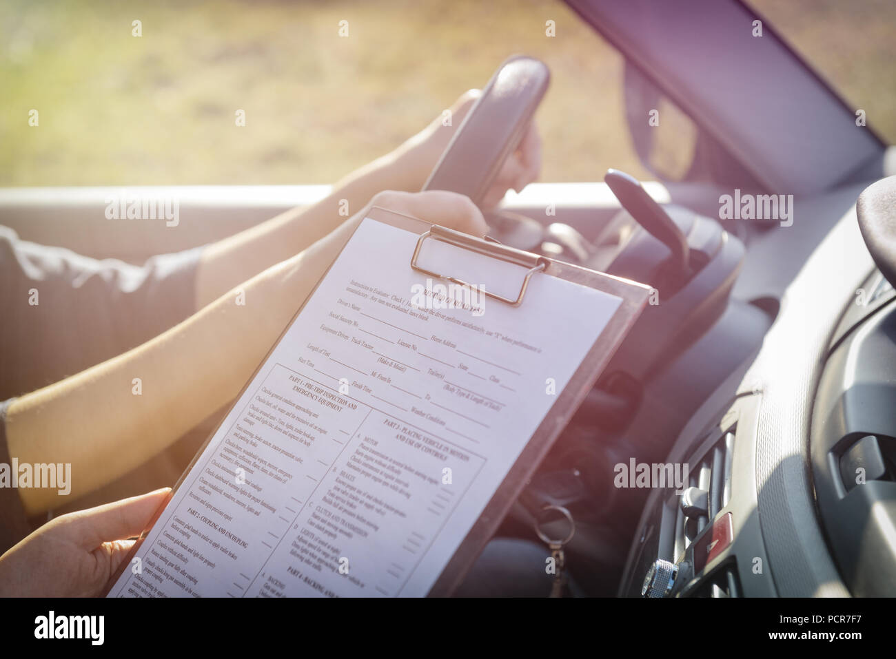Examiner filling in driver's license road test form sitting with her ...