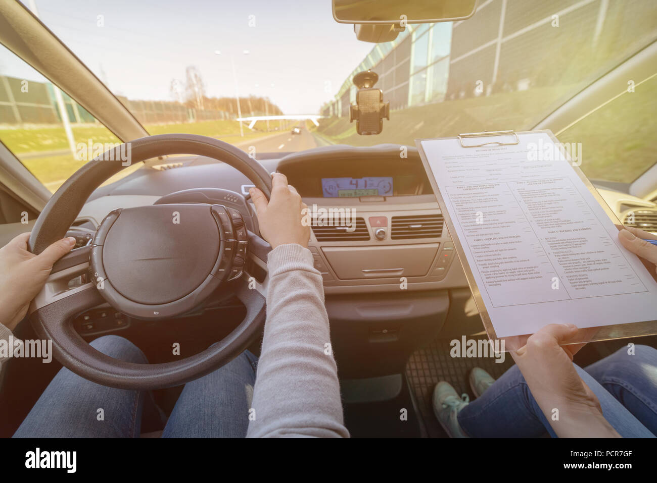 Examiner filling in driver's license road test form sitting with her ...
