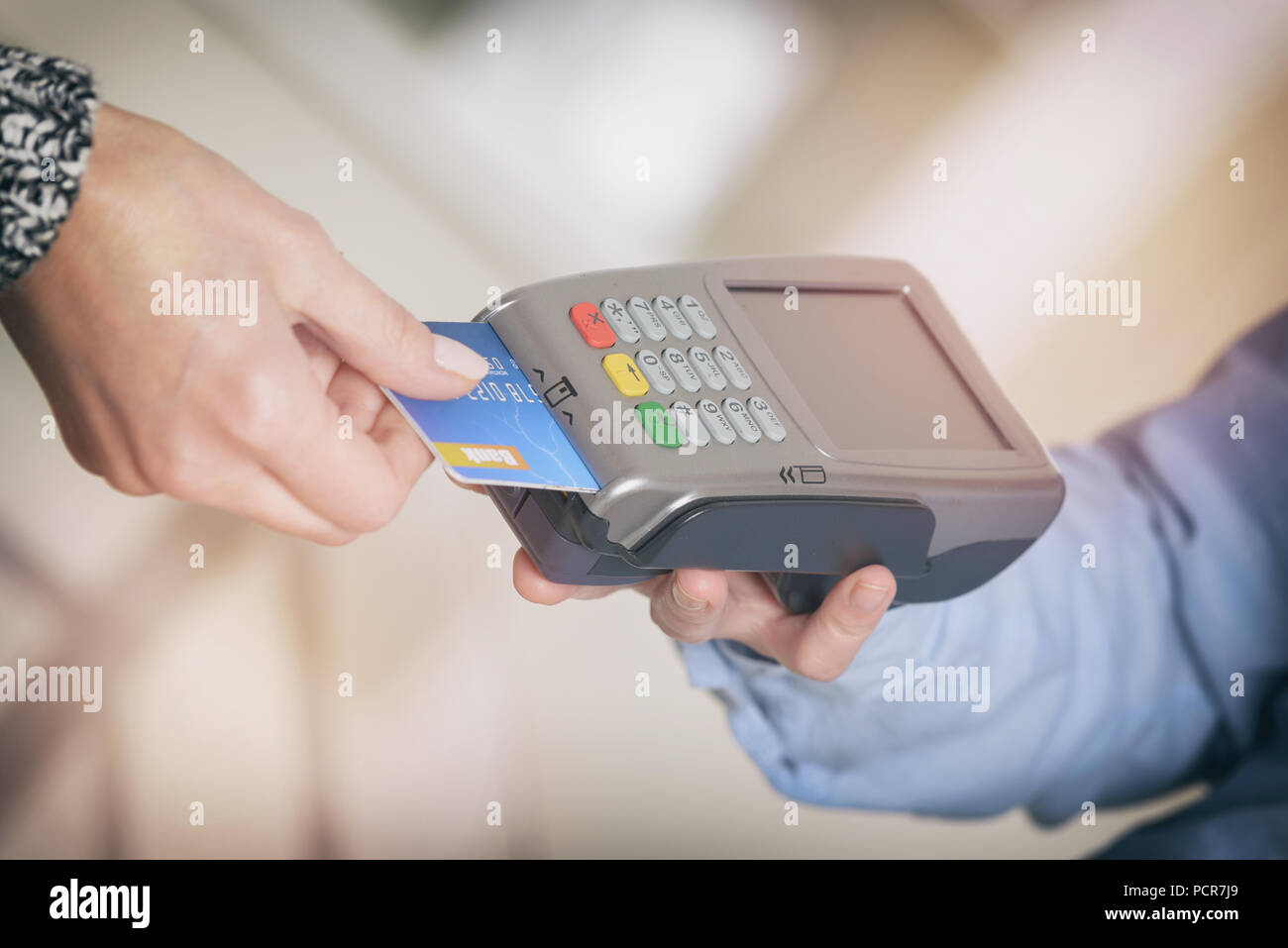 Paying with credit or debit card in wireless payment terminal at shop ...