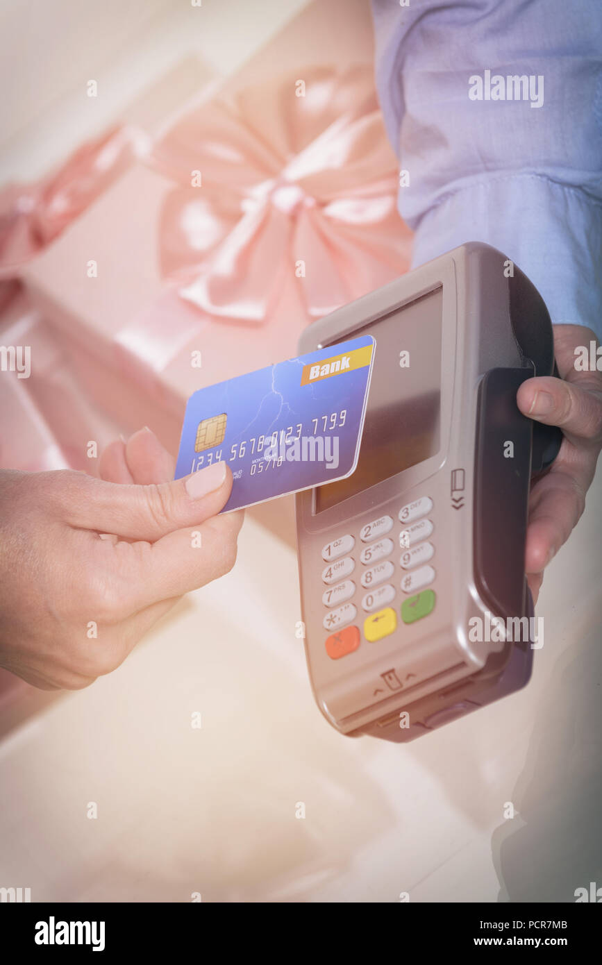 Hand holding contactless credit or debit card over wireless payment ...