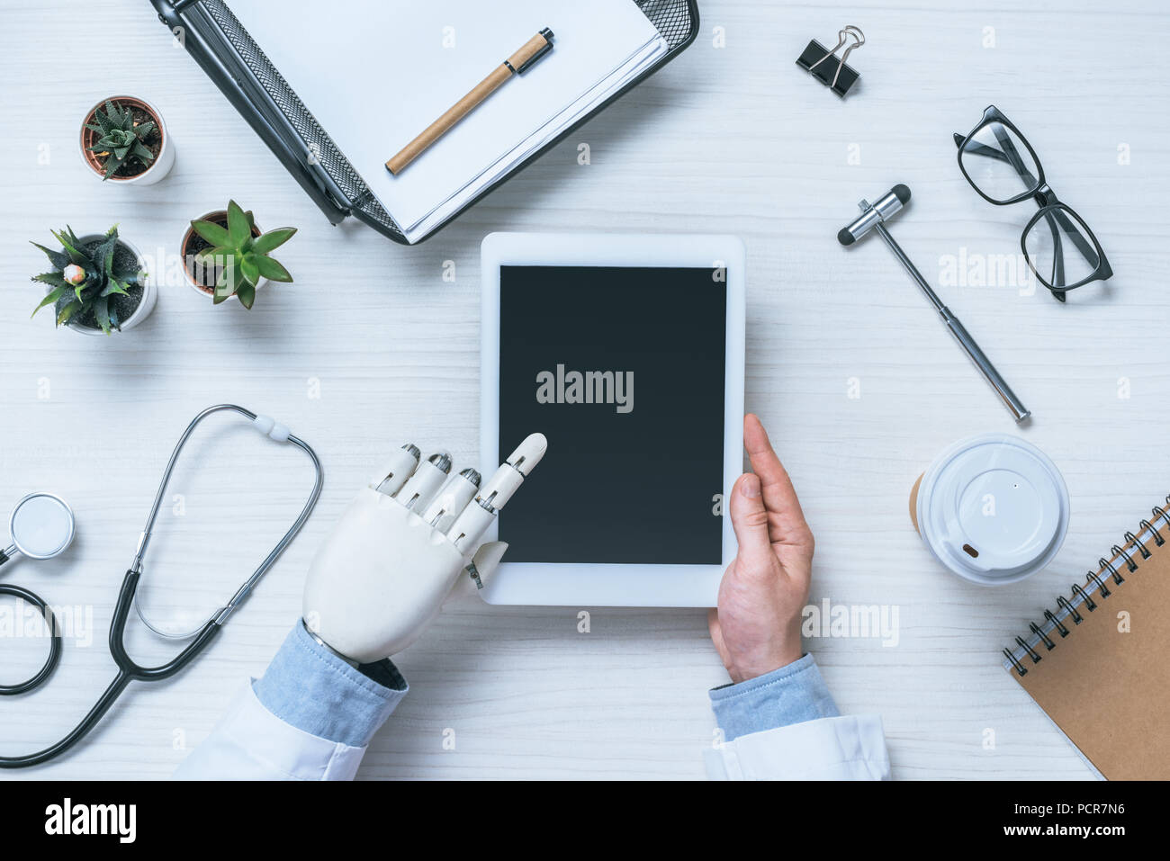 partial view of male doctor with prosthetic arm using digital tablet ...