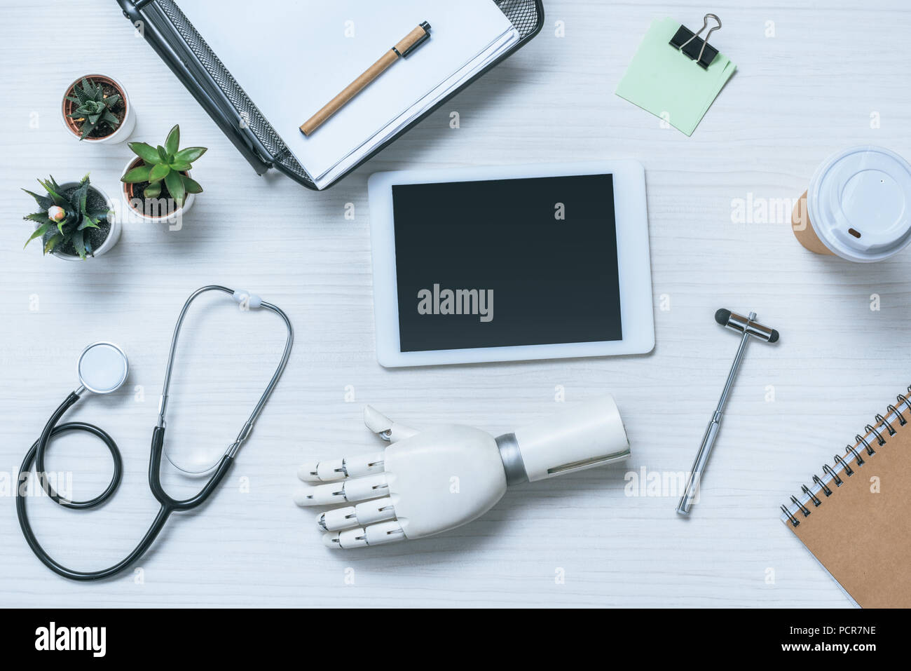 top view of doctor workplace with prosthetic arm, stethoscope, reflex ...