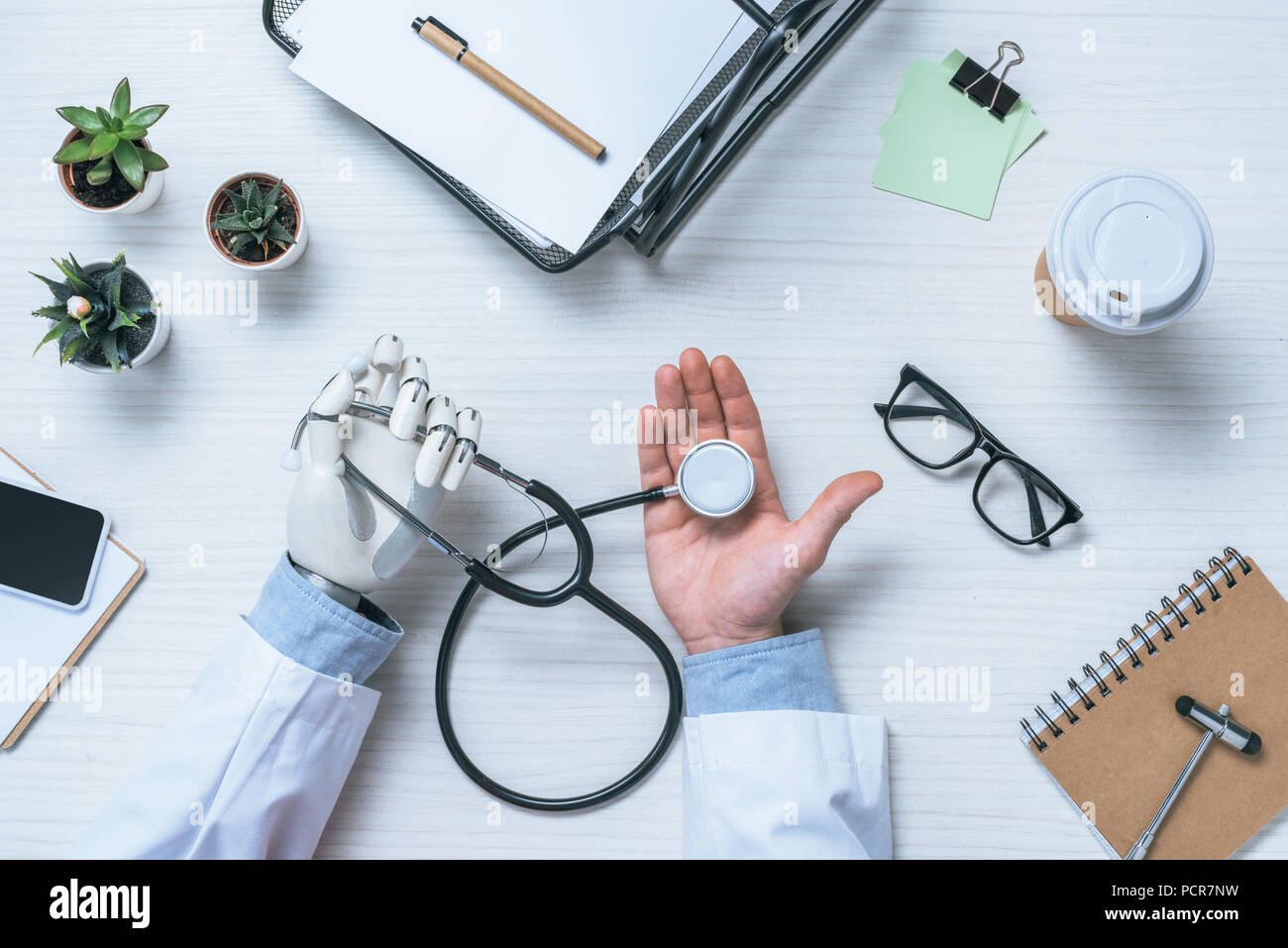 partial view of male doctor with prosthetic arm holding stethoscope ...