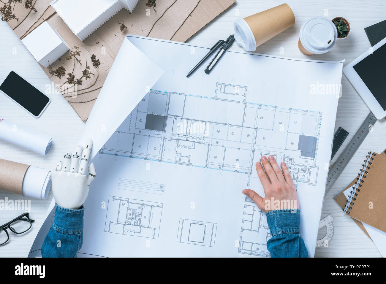 cropped image of male architect with prosthetic arm working with ...