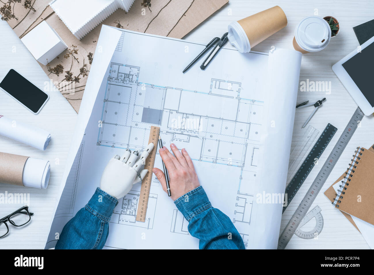 cropped image of male architect with prosthetic arm drawing on ...