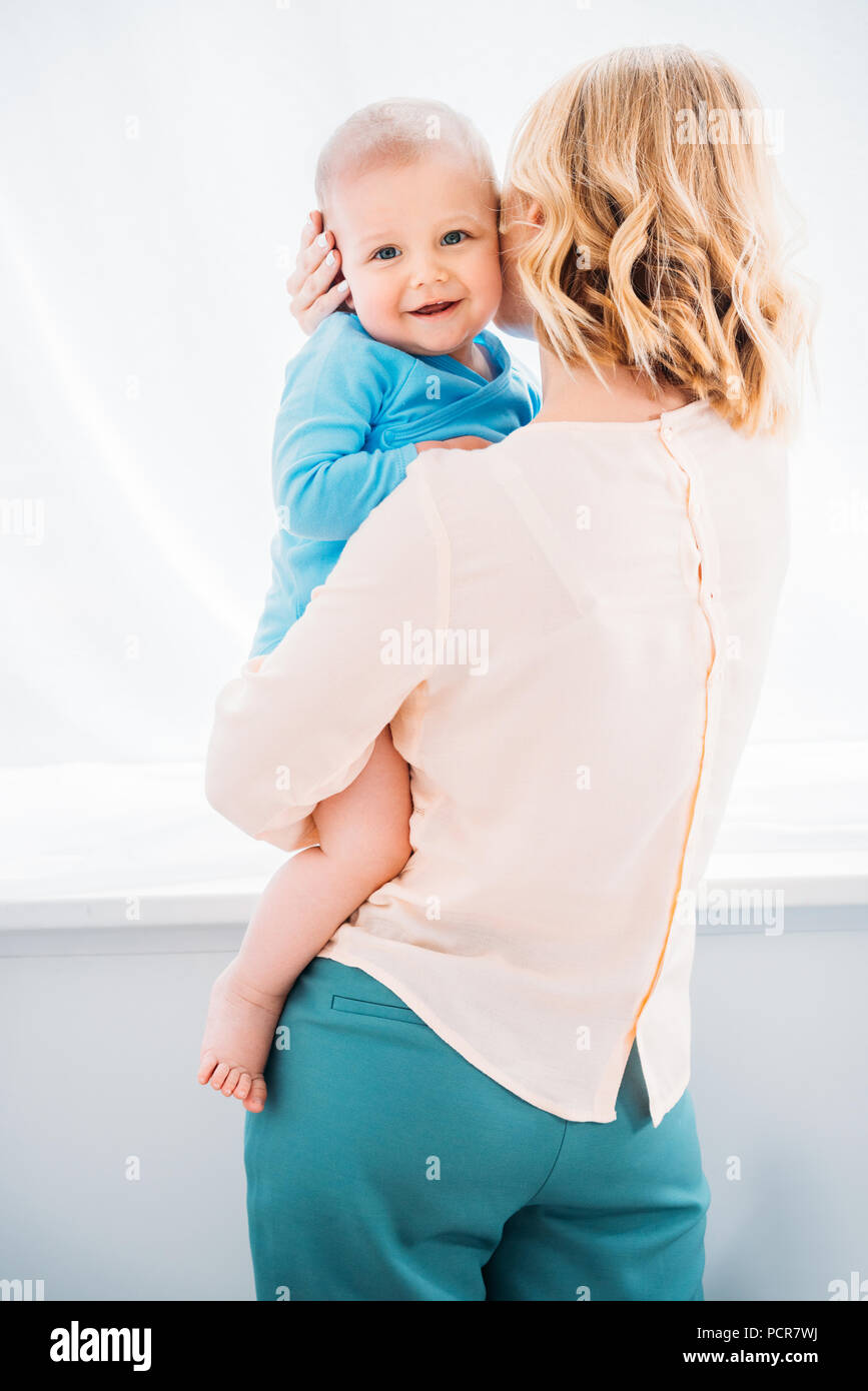 rear view of mother carrying her happy child Stock Photo - Alamy