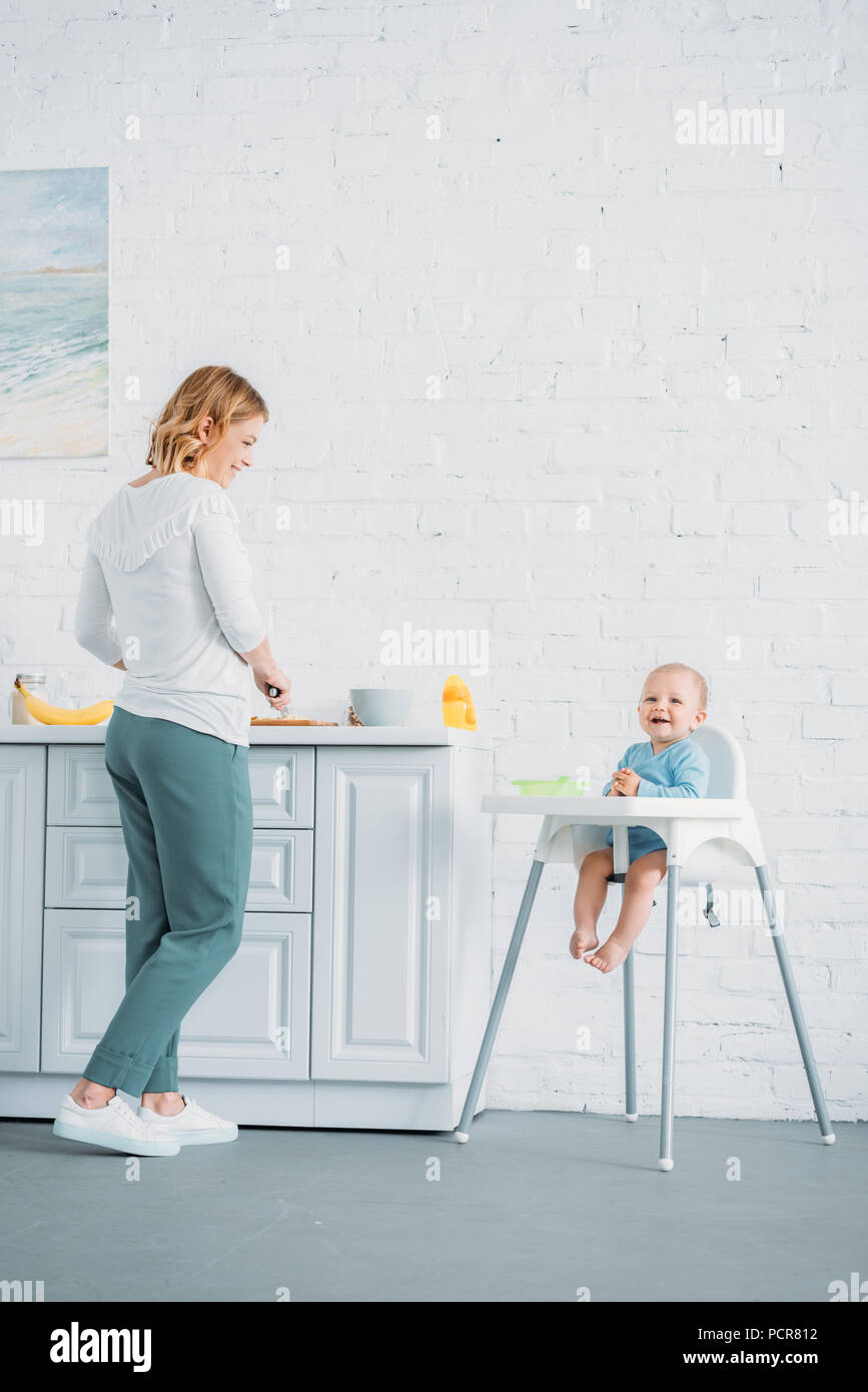 happy mother cooking dinner for her child at home Stock Photo - Alamy