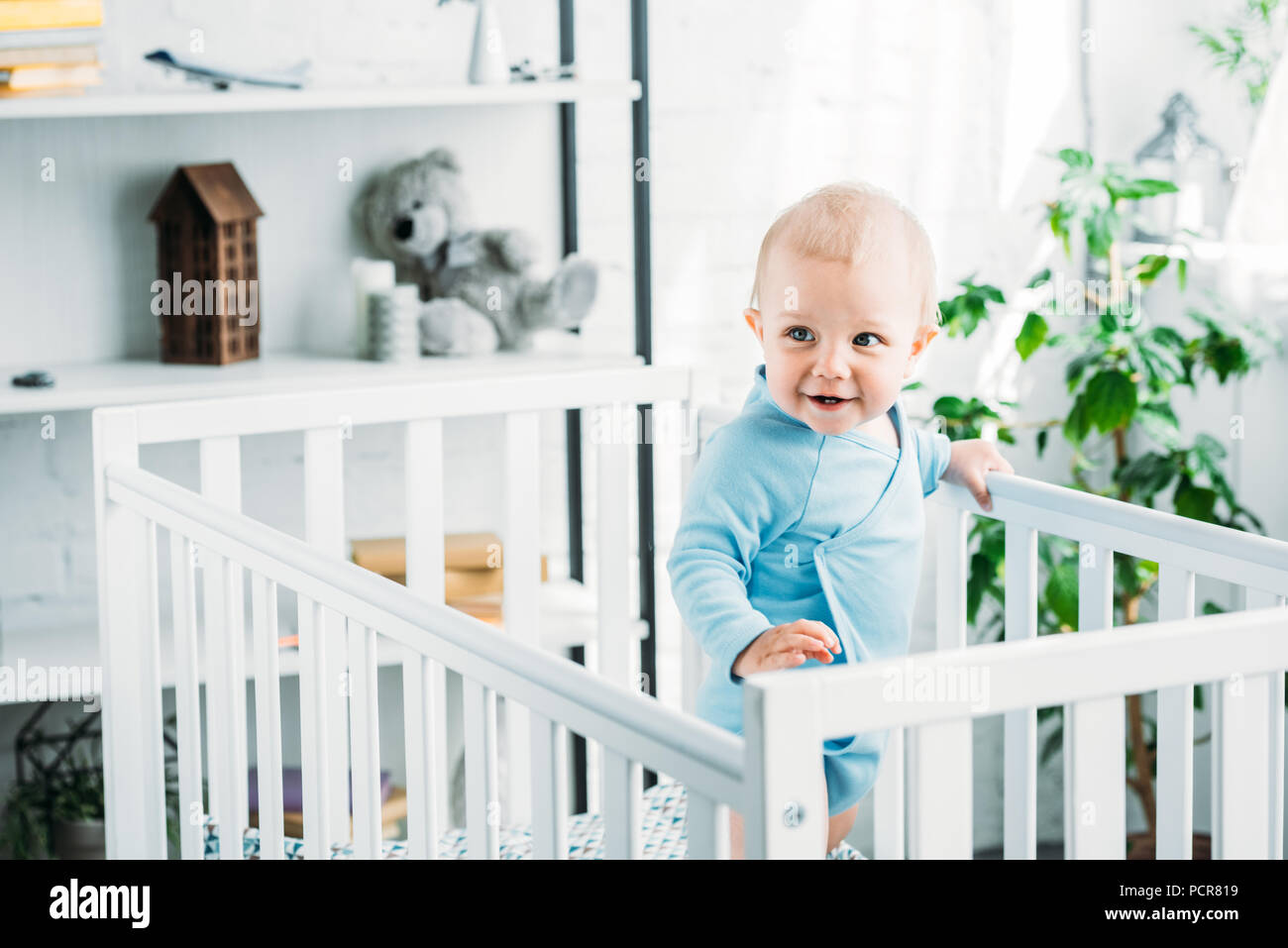 happy little baby standing in crib at home Stock Photo - Alamy