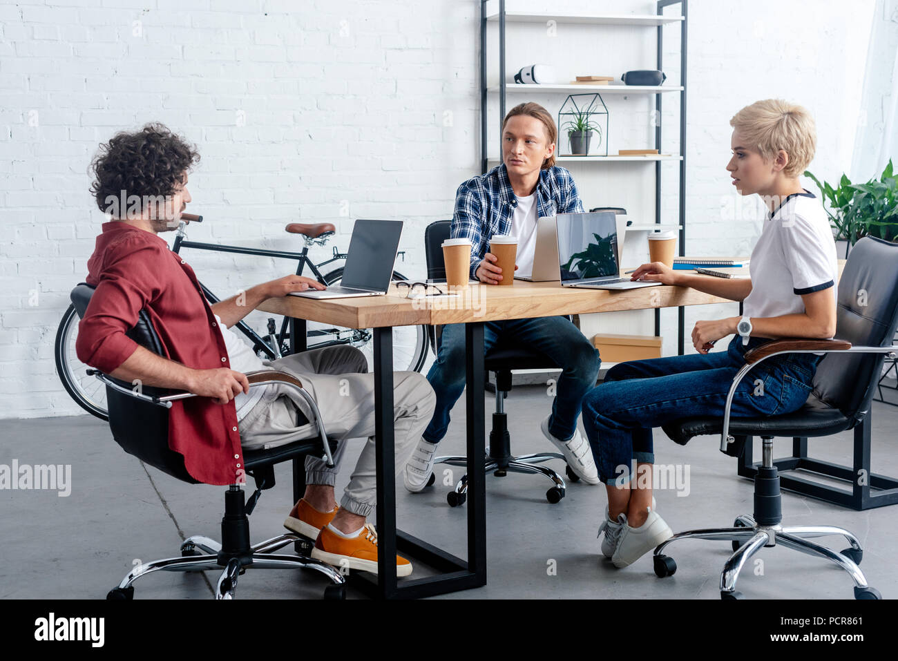 young start up team using digital devices at workplace Stock Photo - Alamy