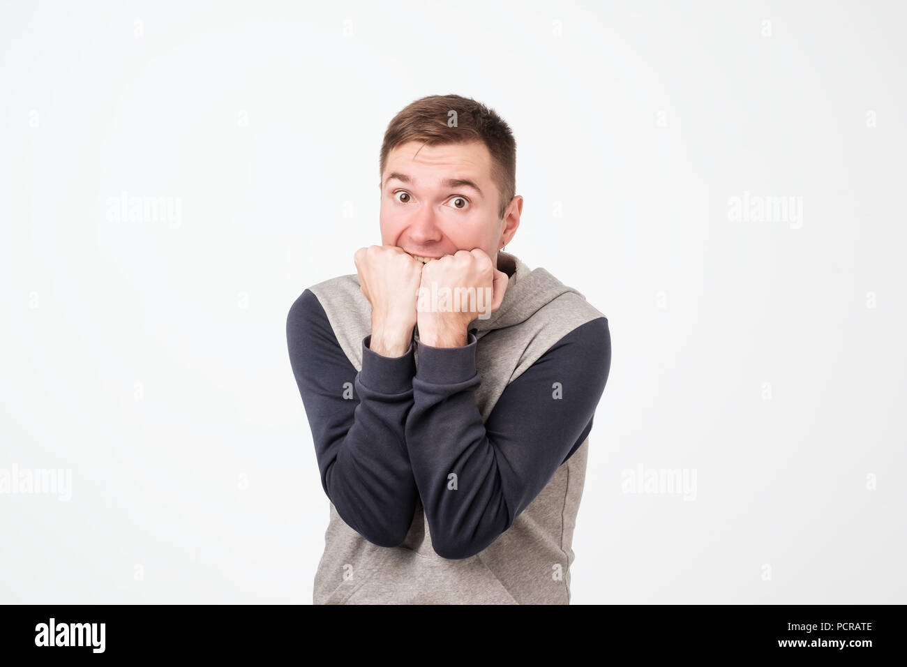 European man covering his mouth with both hands, looking shocked. Surprised, embarrassed and ...