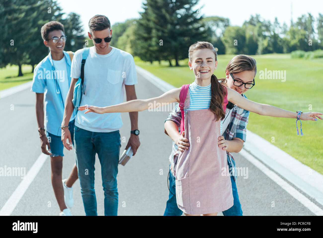 happy multiethnic teenage friends having fun while walking together in ...