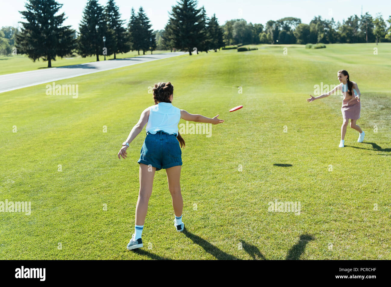 beautiful teenage girls playing with flying disc in park Stock Photo ...