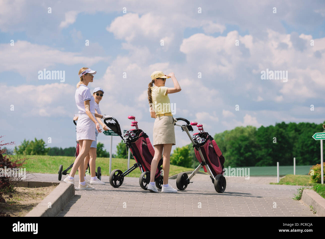 female golfers with golf equipment walking at golf course Stock Photo ...
