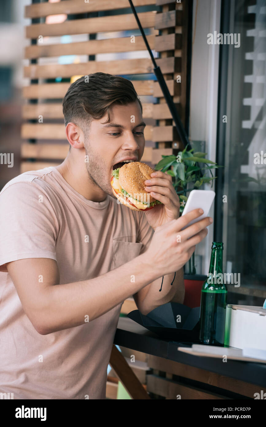 Young man eating junk food restaurant hi-res stock photography and ...
