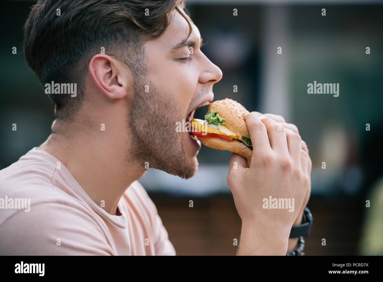 Man eating burger side hi-res stock photography and images - Alamy