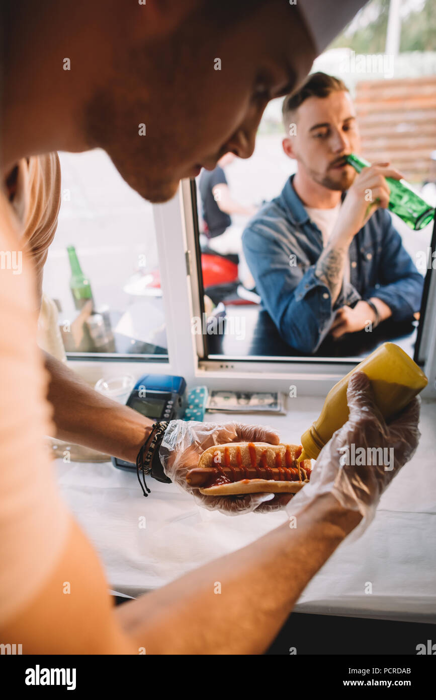 chef preparing hod dog in food truck, customer drinking beer Stock ...