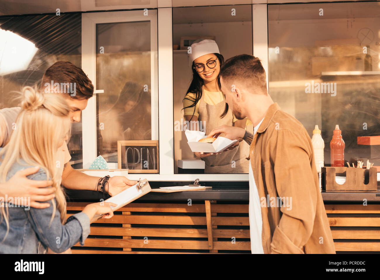 customer taking burger from chef in food truck Stock Photo - Alamy