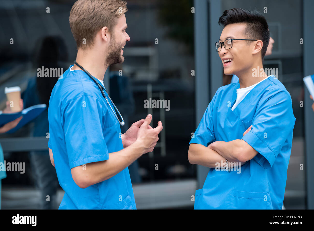 multicultural students talking and laughing near medical university ...