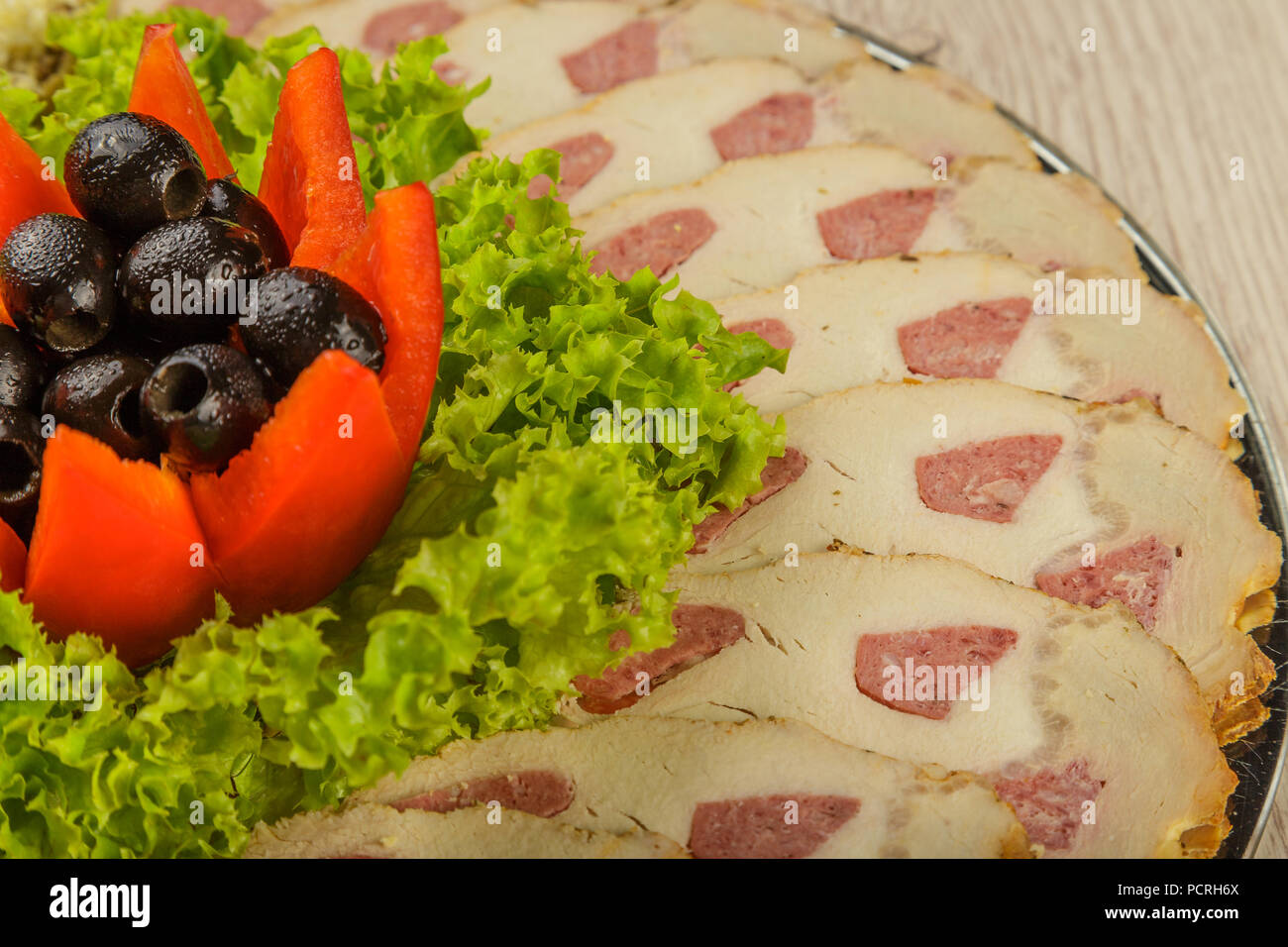 Meat sliced on a mirror dish decorated with verdure Stock Photo - Alamy
