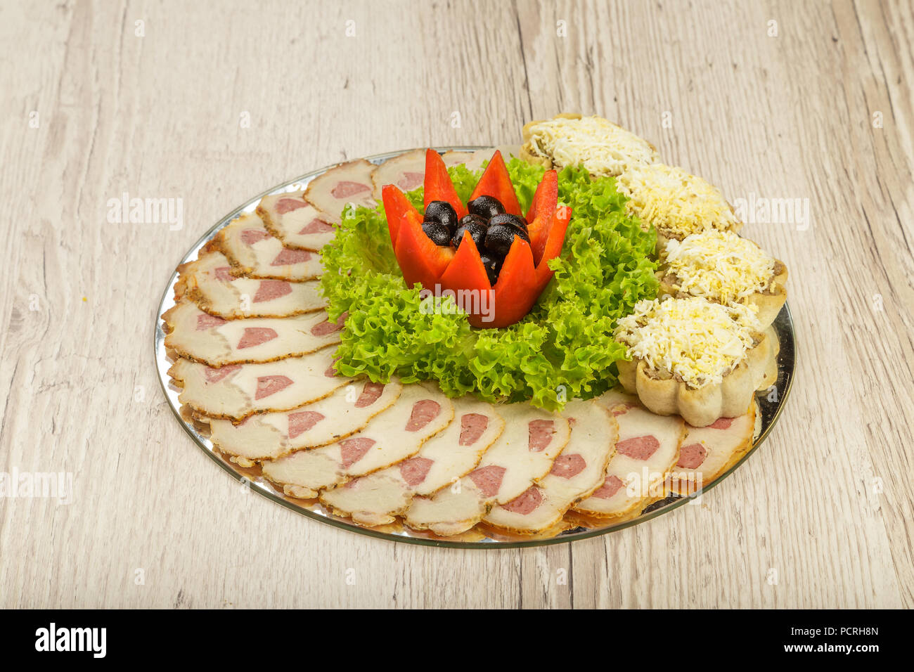 Meat sliced on a mirror dish decorated with verdure Stock Photo - Alamy