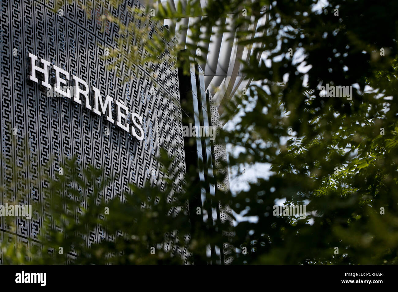 A logo sign outside of a Hermes retail store location in Denver ...