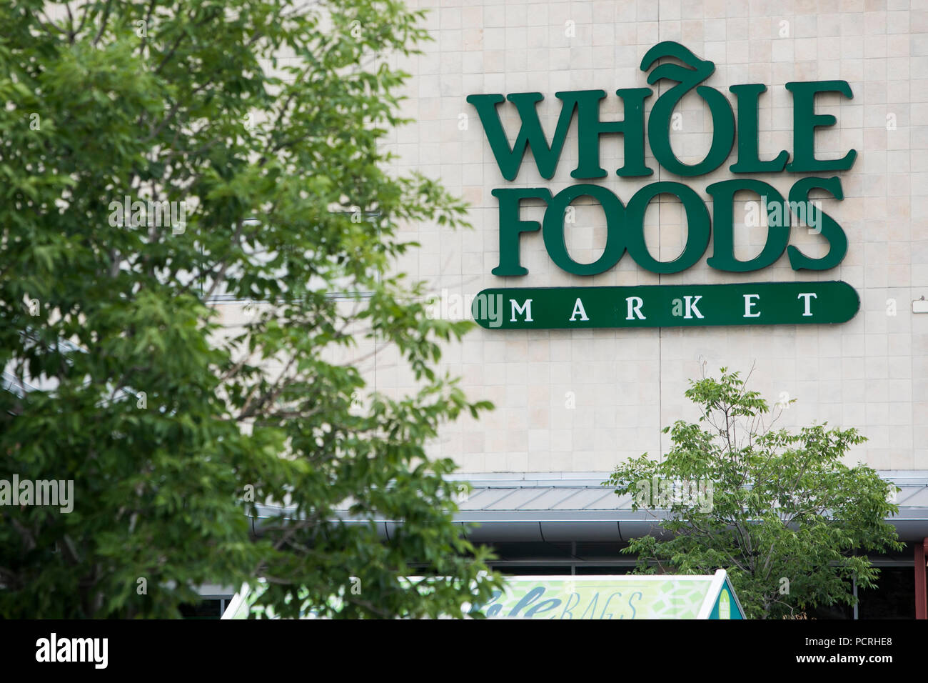 A logo sign outside of a Whole Foods Market grocery store location in ...