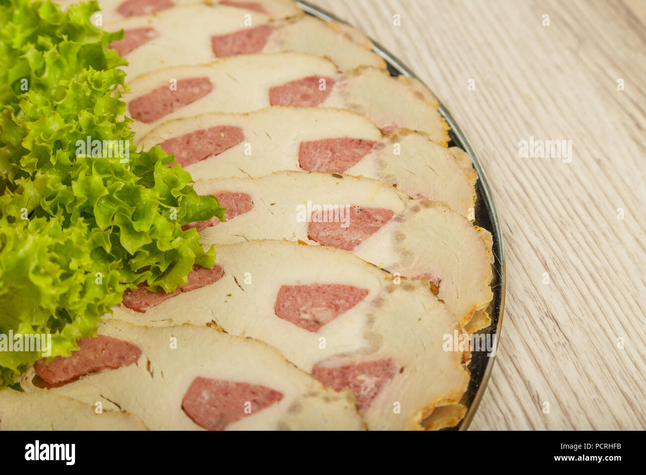Meat sliced on a mirror dish decorated with verdure Stock Photo - Alamy