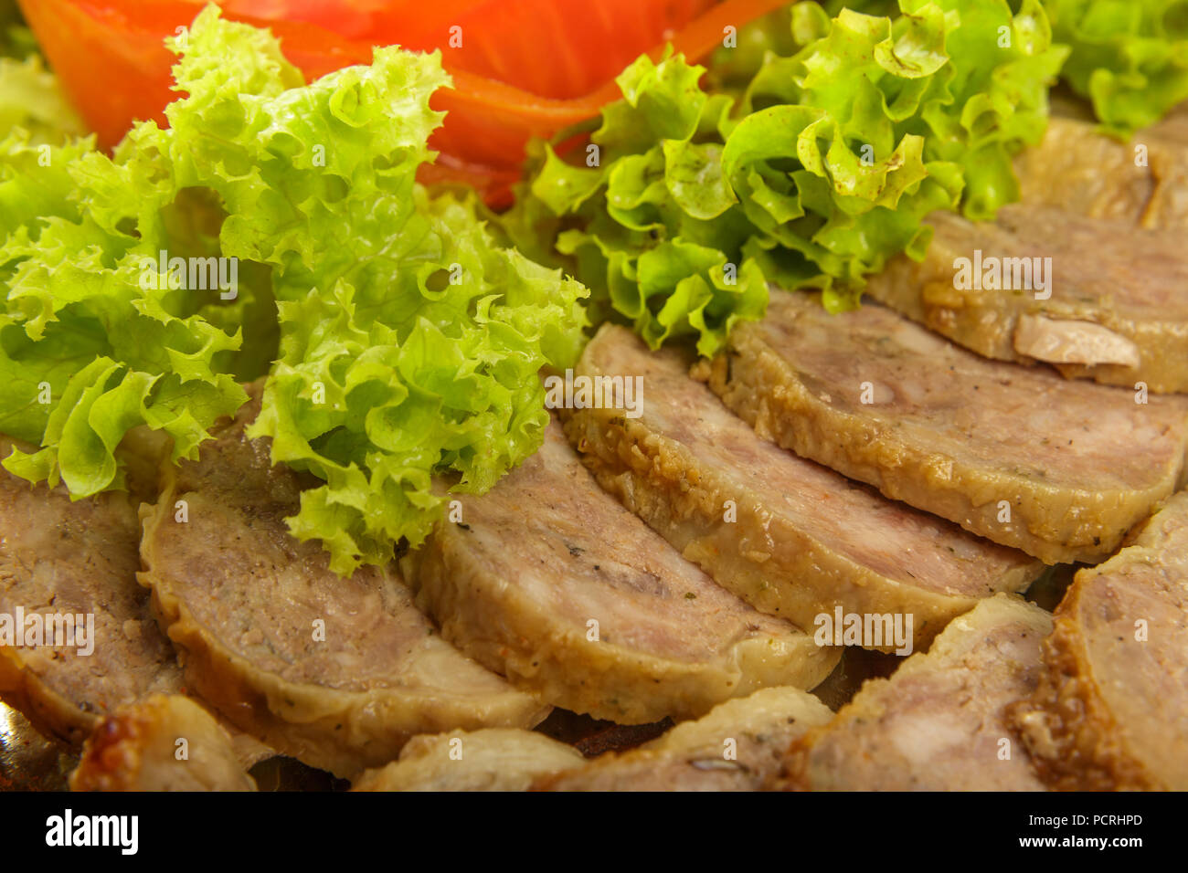 Meat sliced on a mirror dish decorated with verdure Stock Photo - Alamy