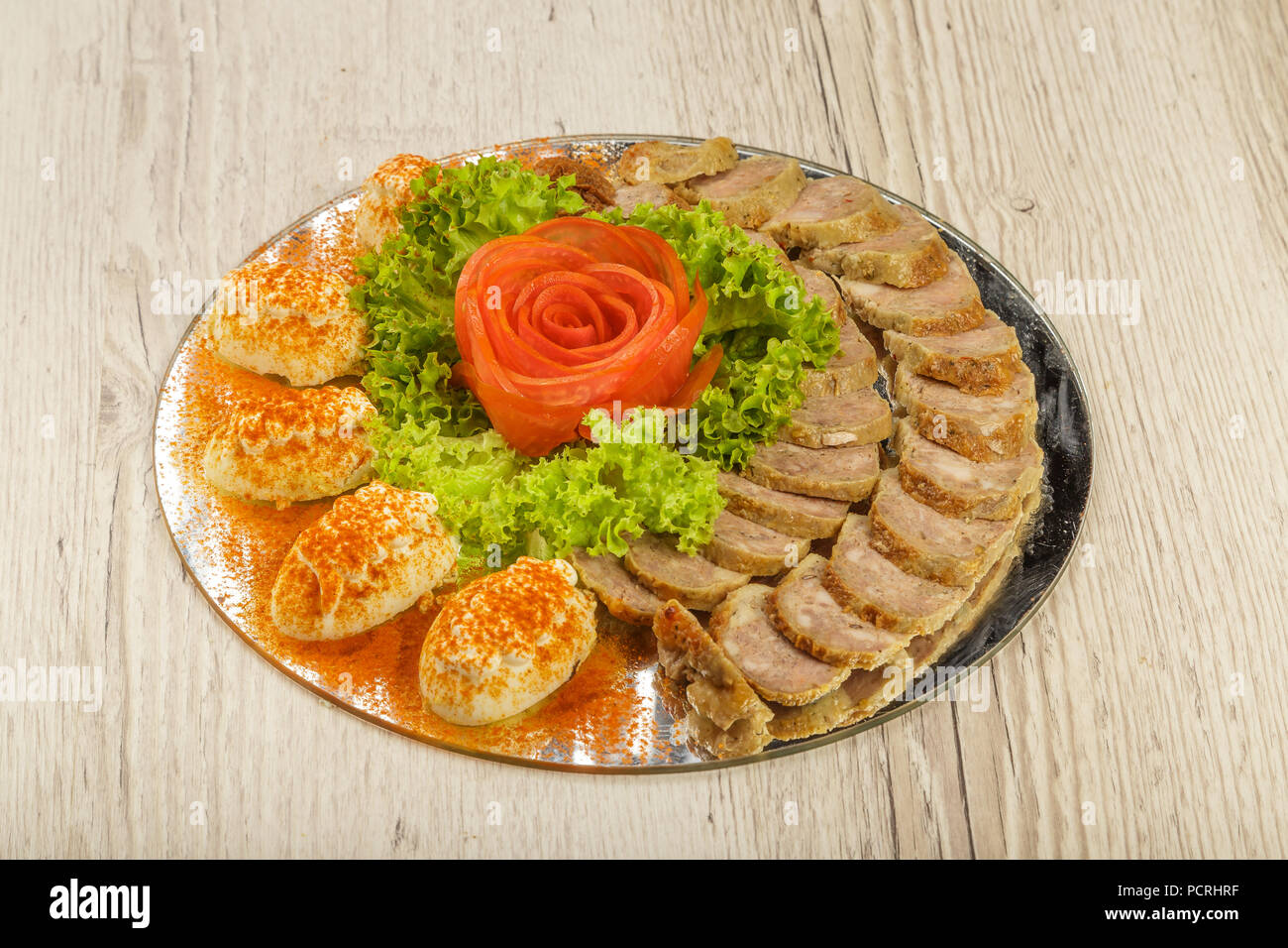 Meat sliced on a mirror dish decorated with verdure Stock Photo - Alamy