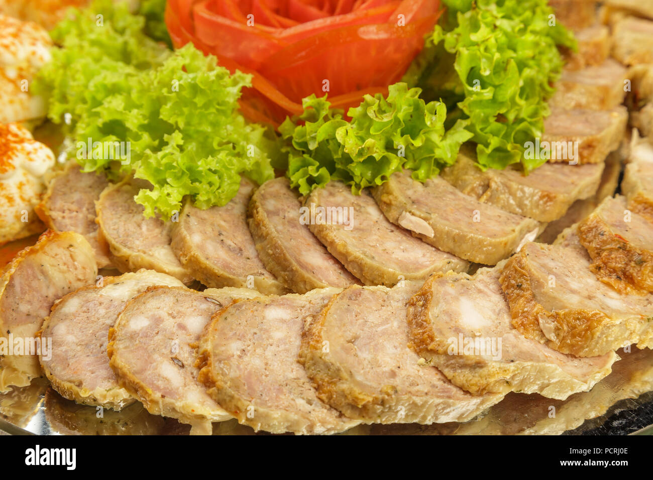 Meat sliced on a mirror dish decorated with verdure Stock Photo - Alamy