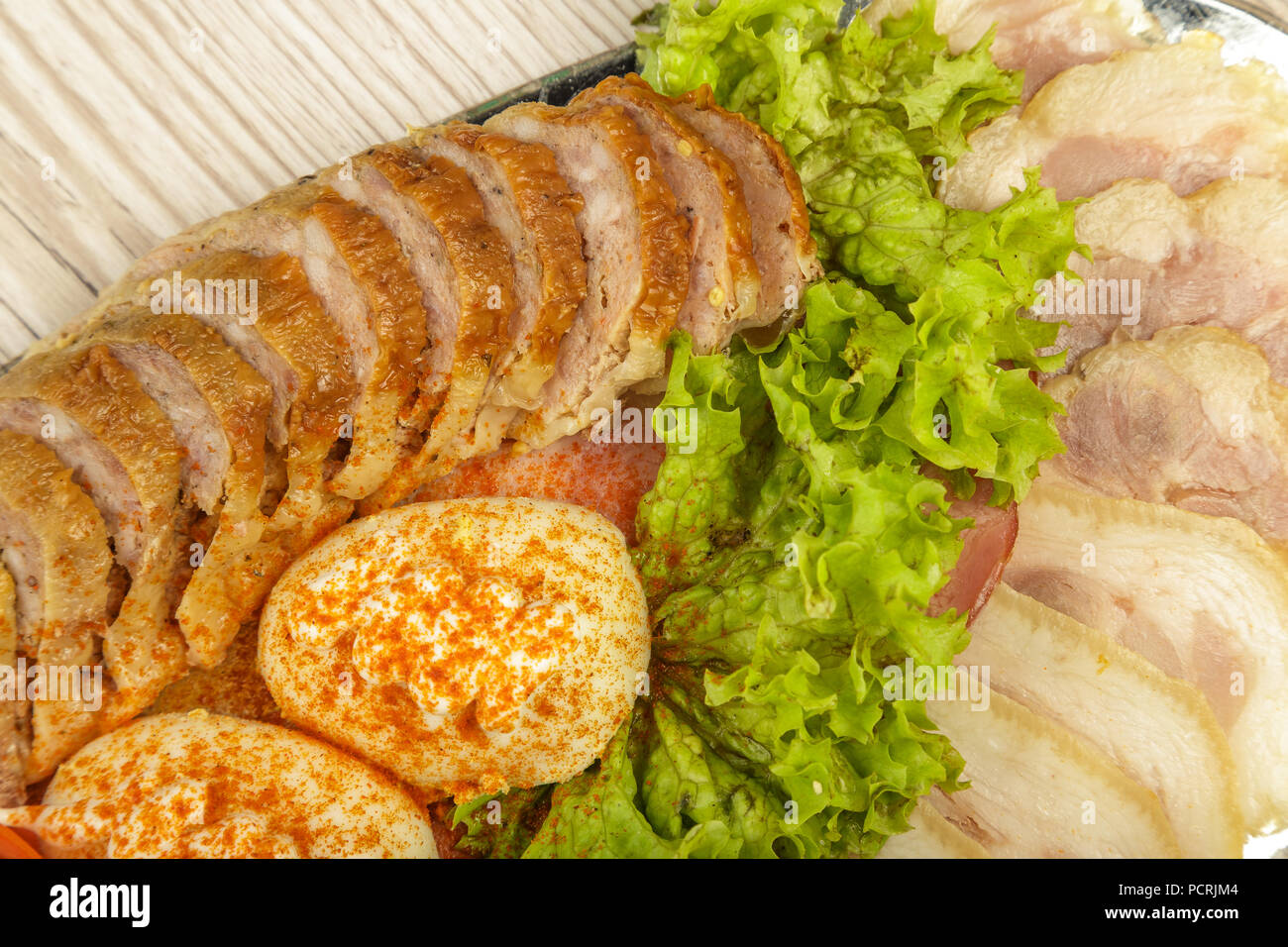 Meat sliced on a mirror dish decorated with verdure Stock Photo - Alamy