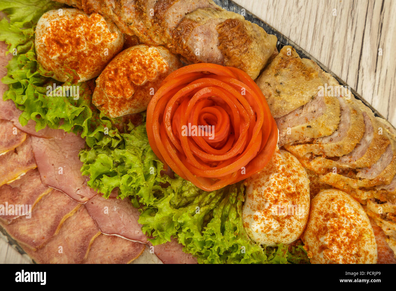 Meat sliced on a mirror dish decorated with verdure Stock Photo - Alamy