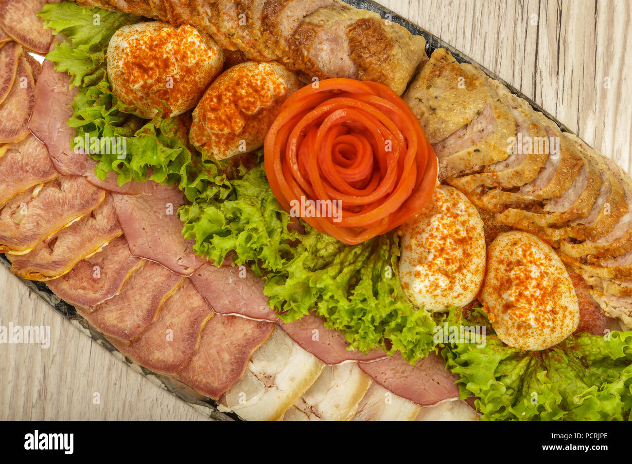 Meat sliced on a mirror dish decorated with verdure Stock Photo - Alamy
